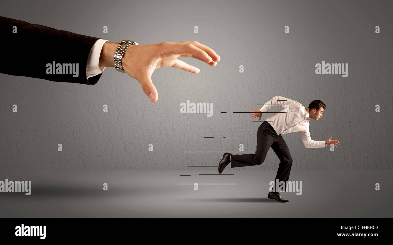 Businessman running away from a huge hand Stock Photo - Alamy