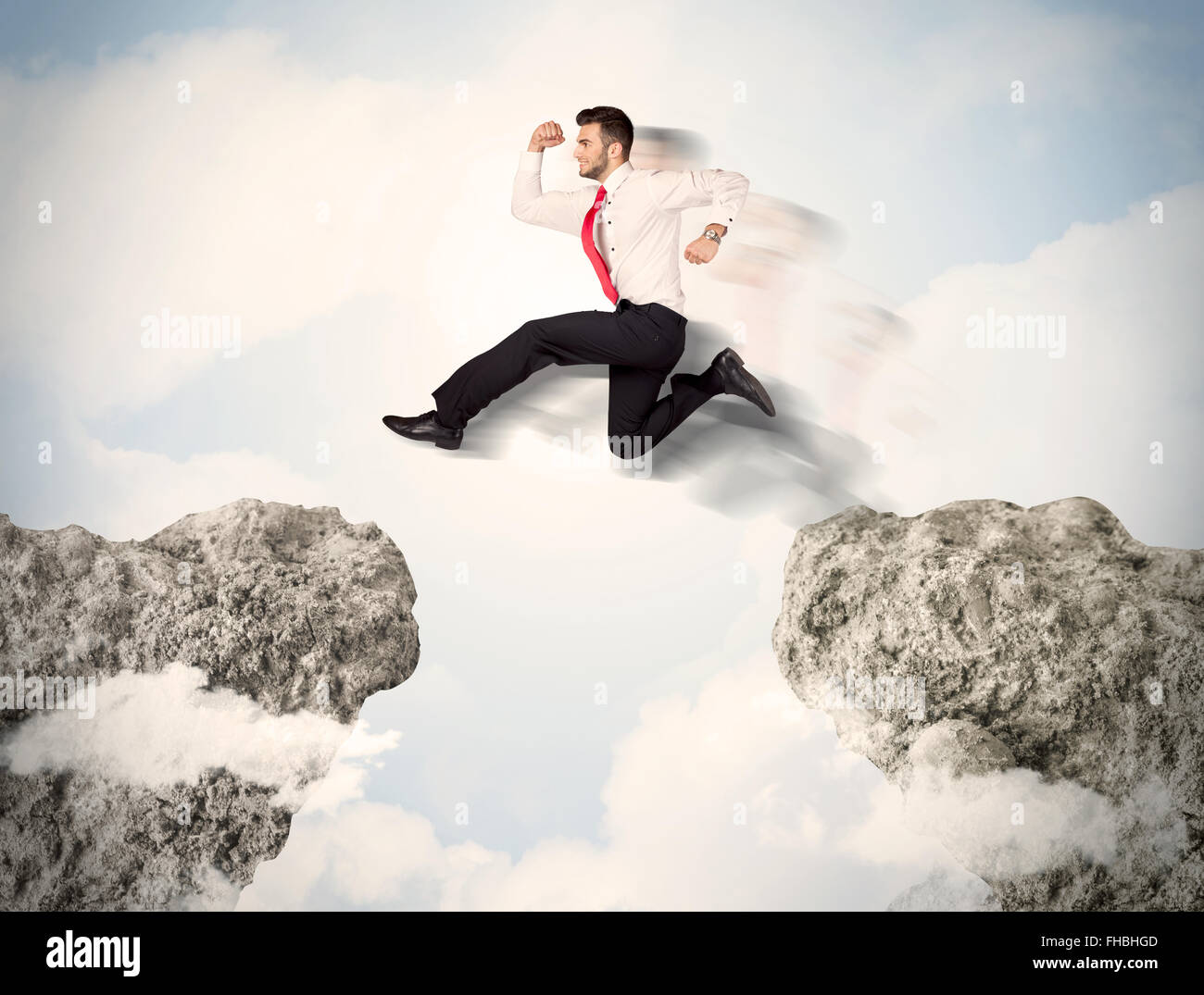 Happy business man jumping over a cliff Stock Photo - Alamy