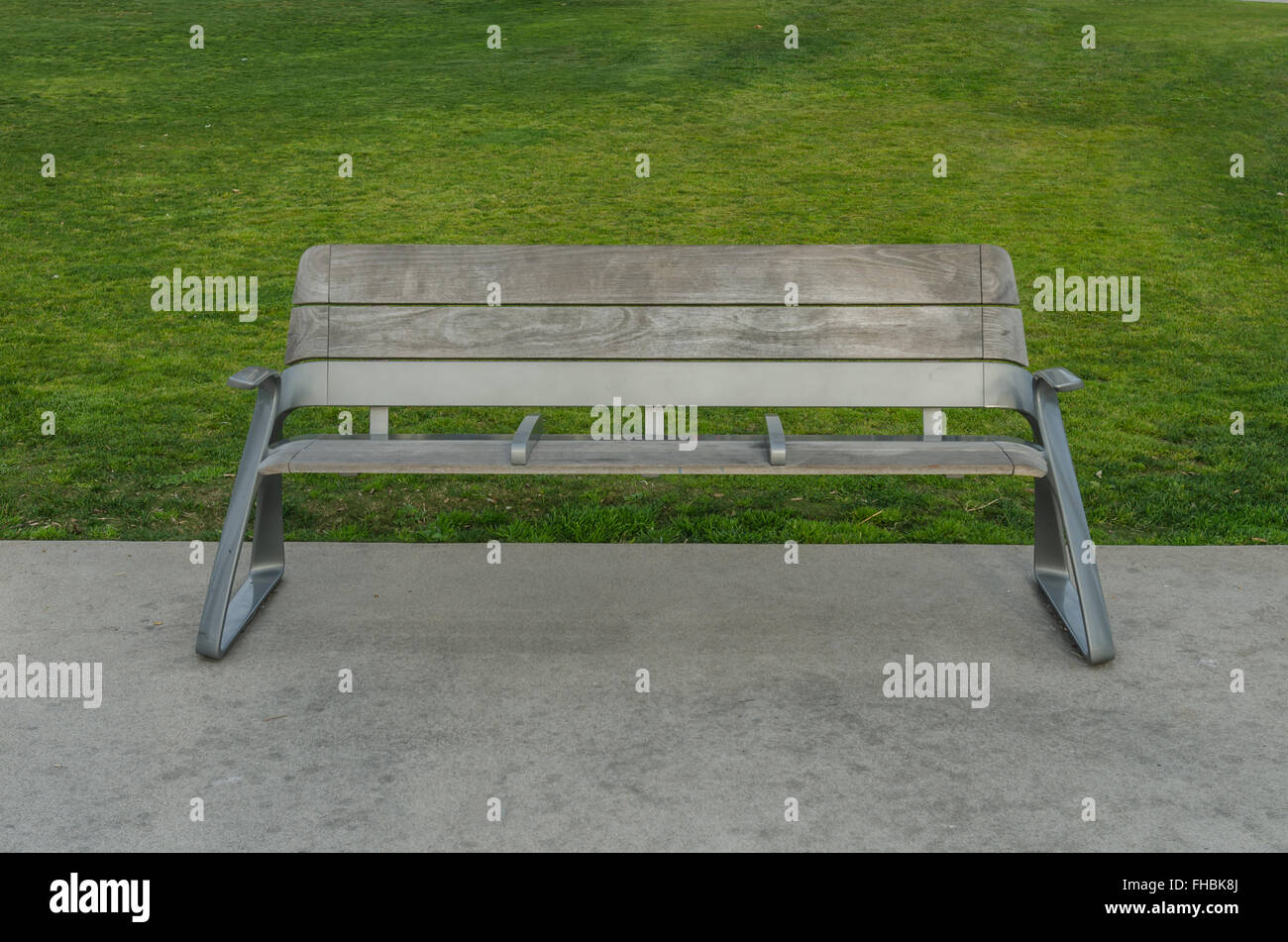Modern park bench with green grass behind it Stock Photo - Alamy
