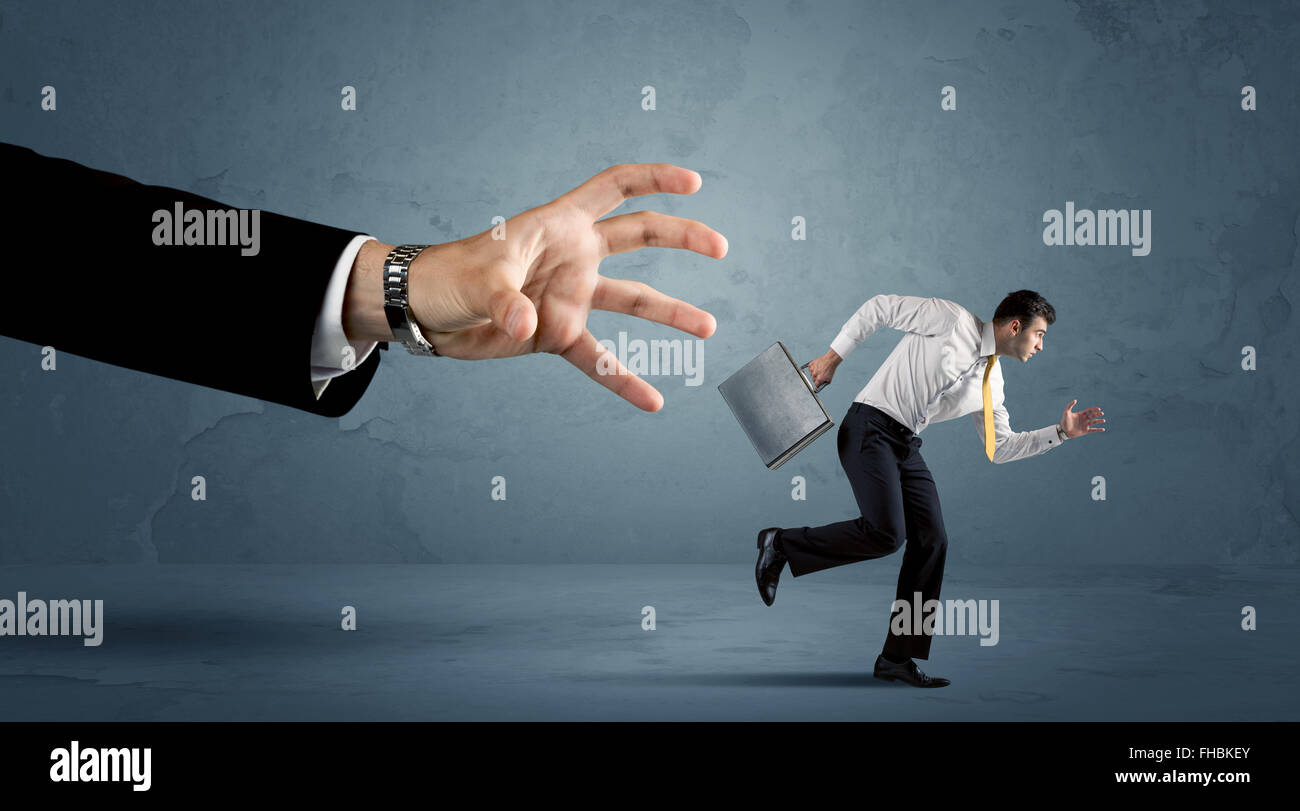 Business man running away from a huge hand concept Stock Photo - Alamy