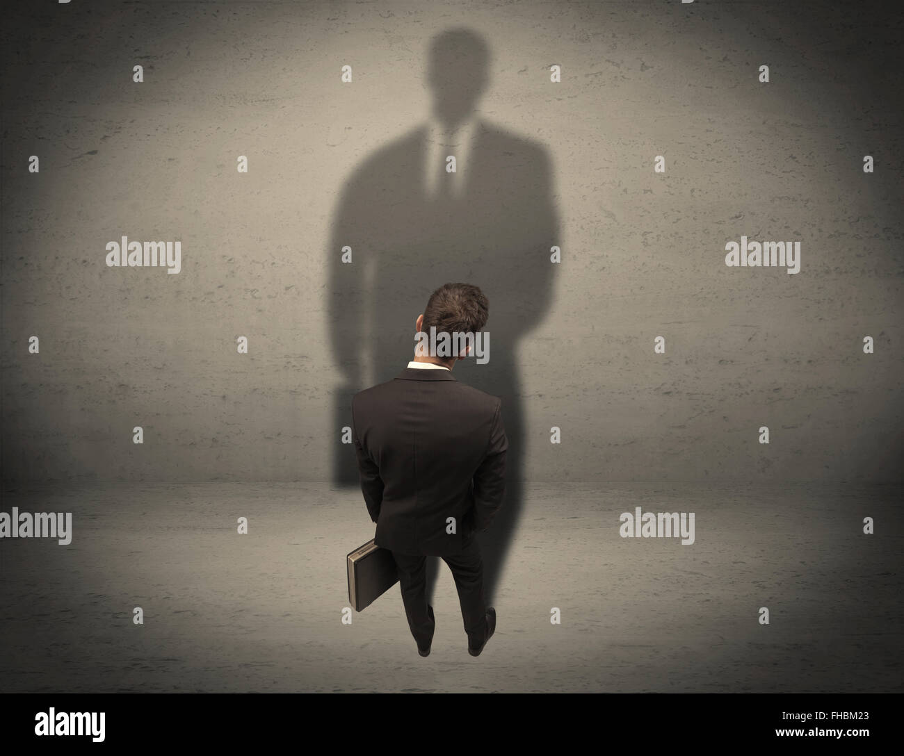 Businessman looking at big shadow concept Stock Photo - Alamy