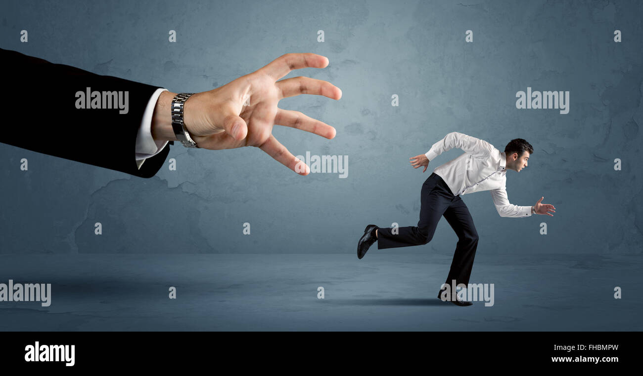 Business man running away from a huge hand concept Stock Photo - Alamy