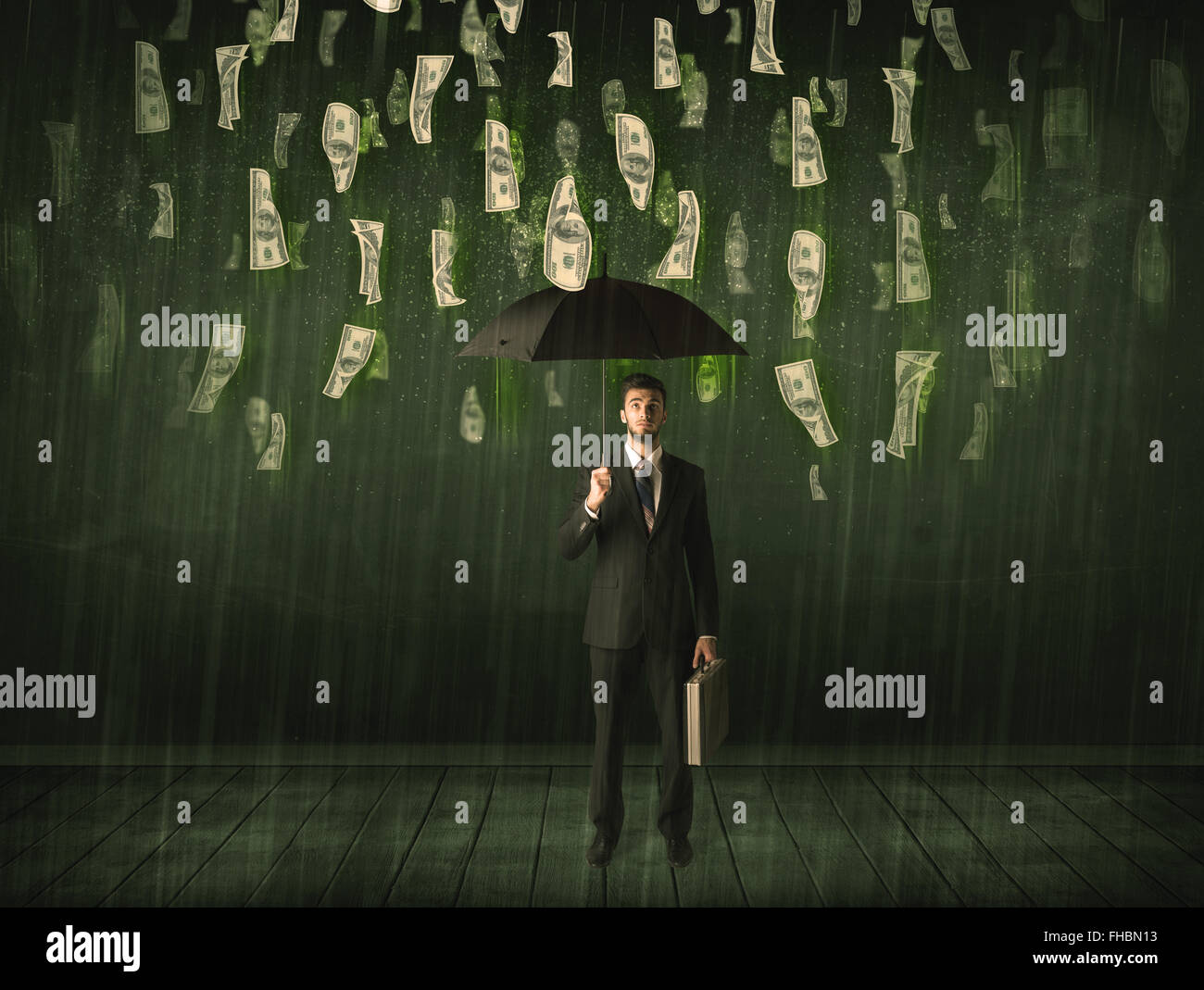 Businessman standing with umbrella in dollar bill rain concept Stock ...