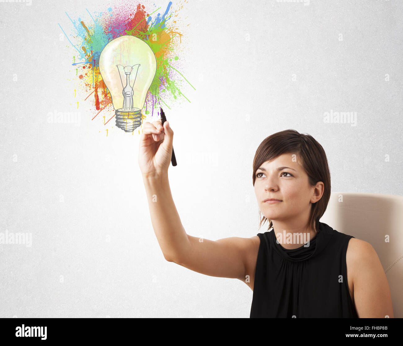 Young lady drawing a colorful light bulb with colorful splashes Stock ...