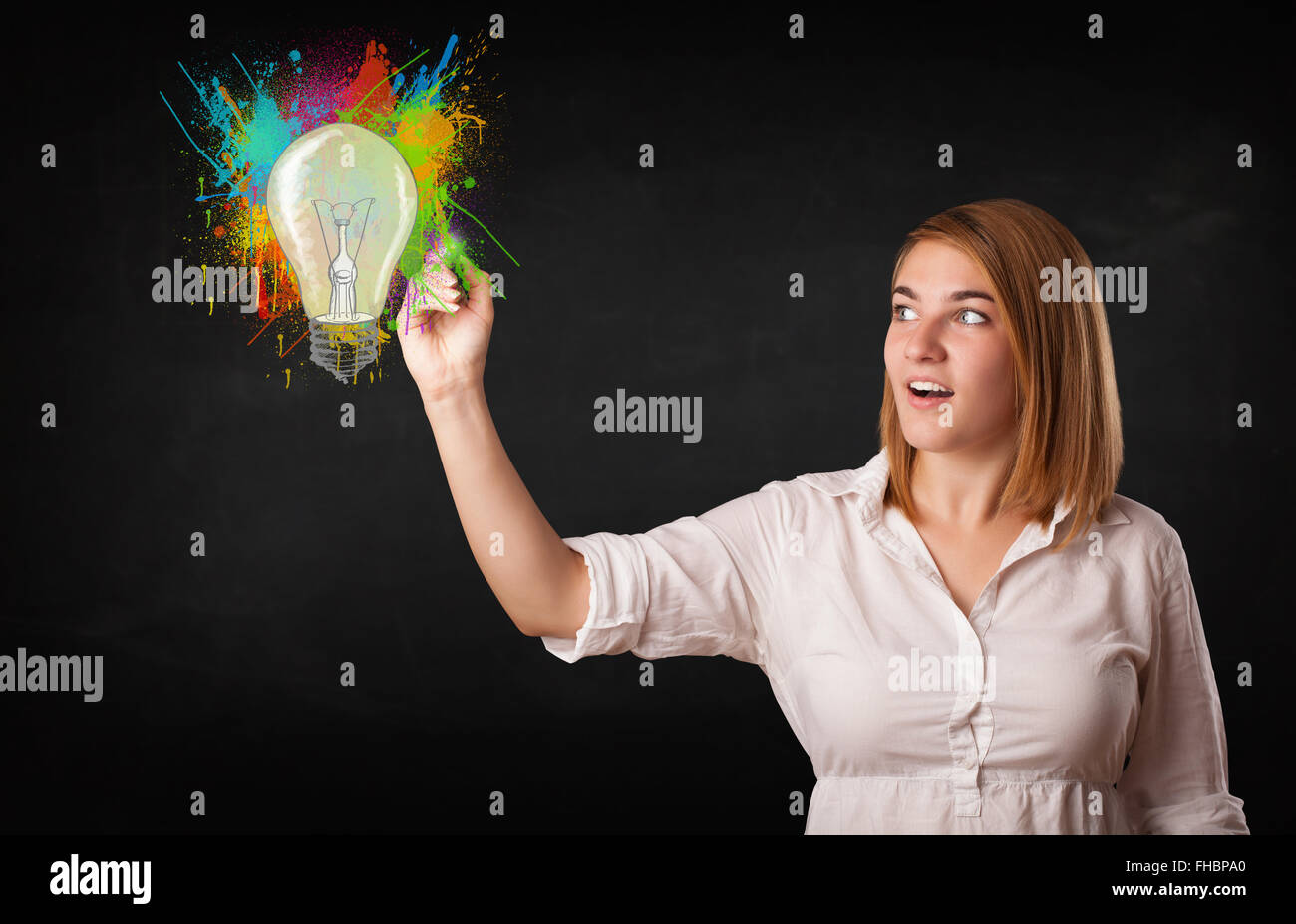Young lady drawing a colorful light bulb with colorful splashes Stock ...