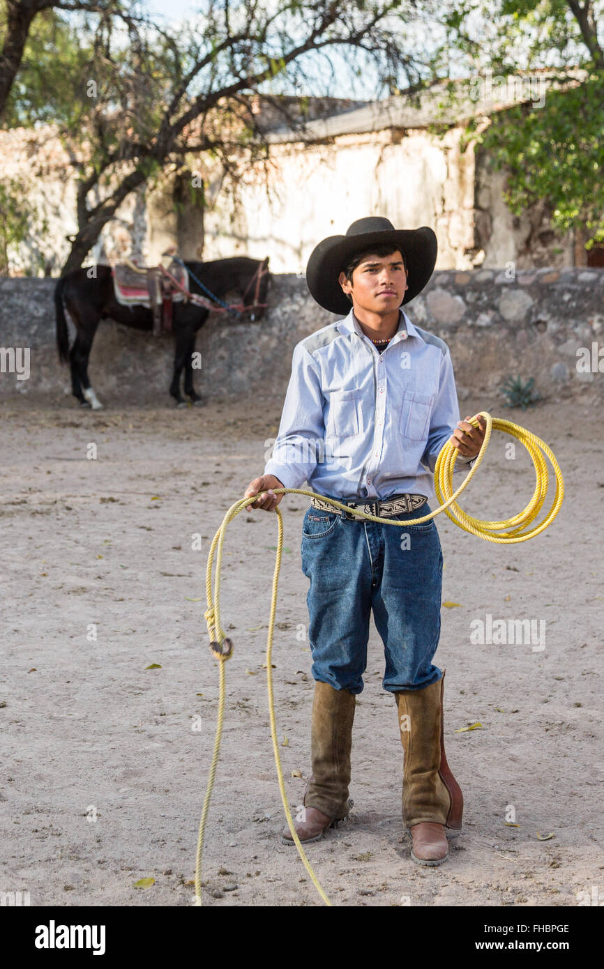 A Mexican charro or cowboy poses in cowboy hat and lasso at a hacienda ...