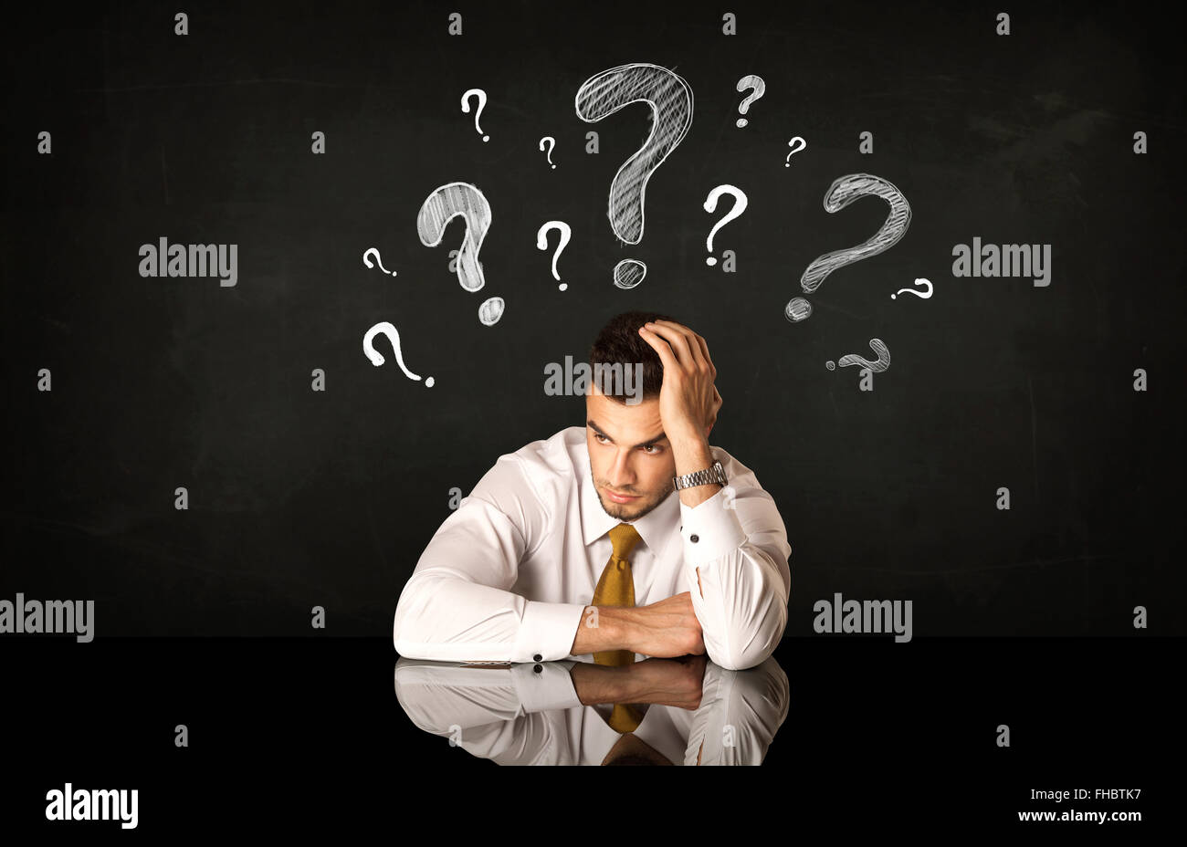 Sitting businessman under question marks Stock Photo - Alamy