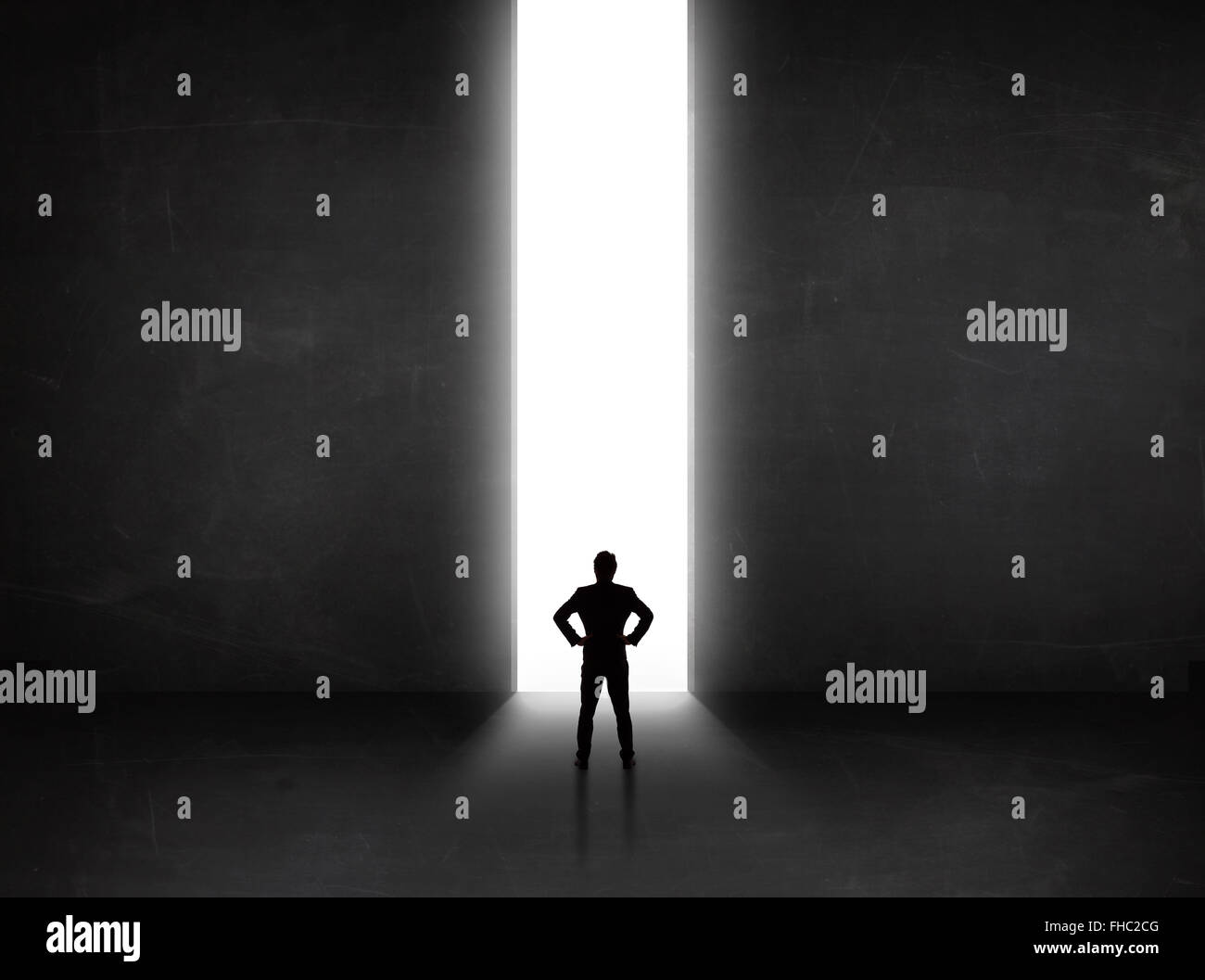 Business person looking at wall with light tunnel opening Stock Photo ...