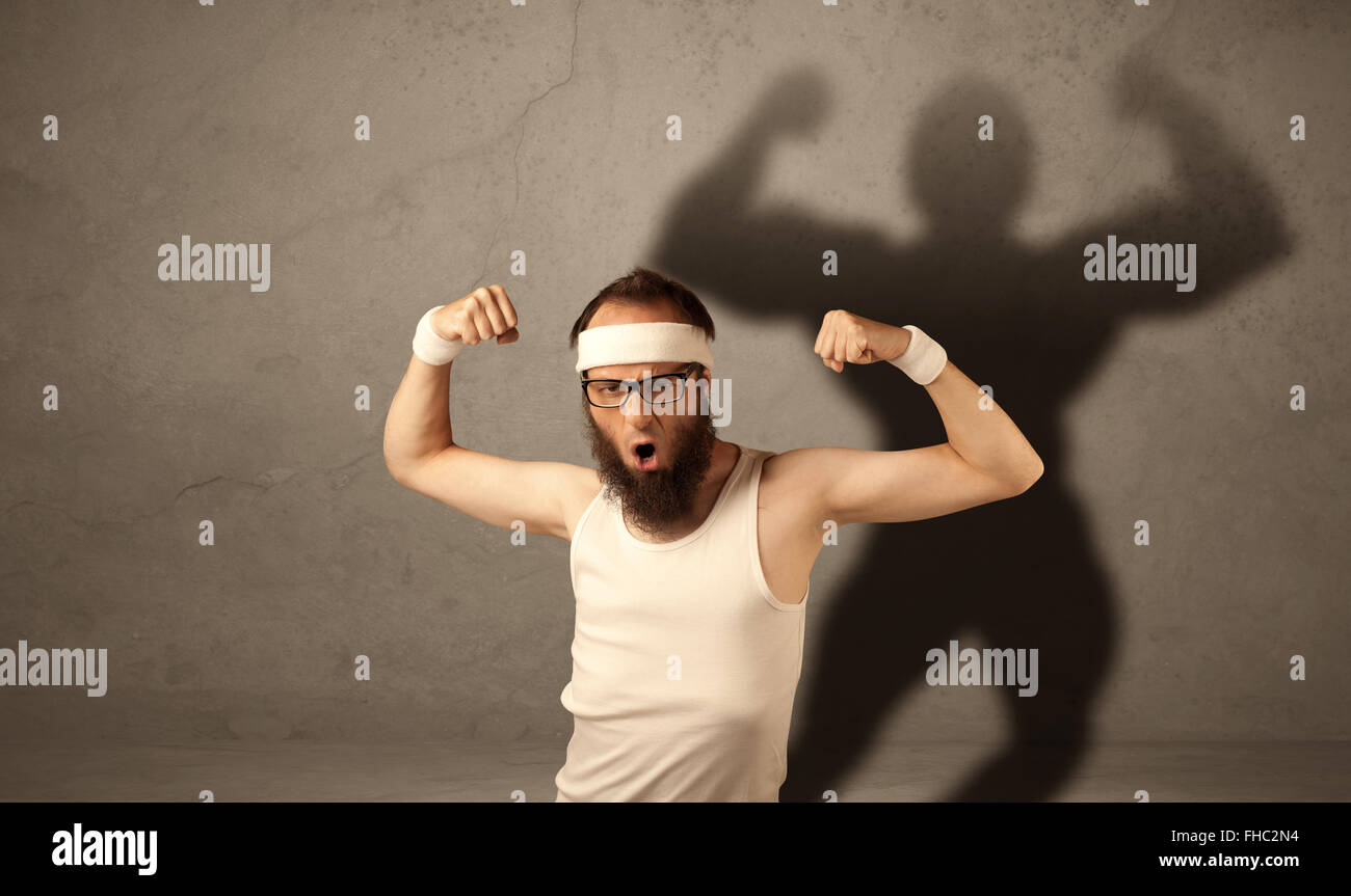 Skinny man with musculous shadow Stock Photo - Alamy
