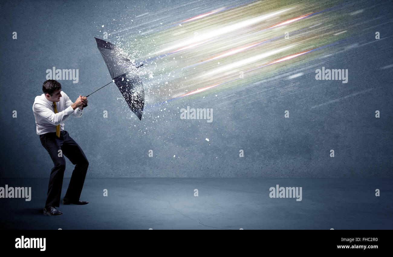 Business man defending light beams with umbrella concept Stock Photo ...