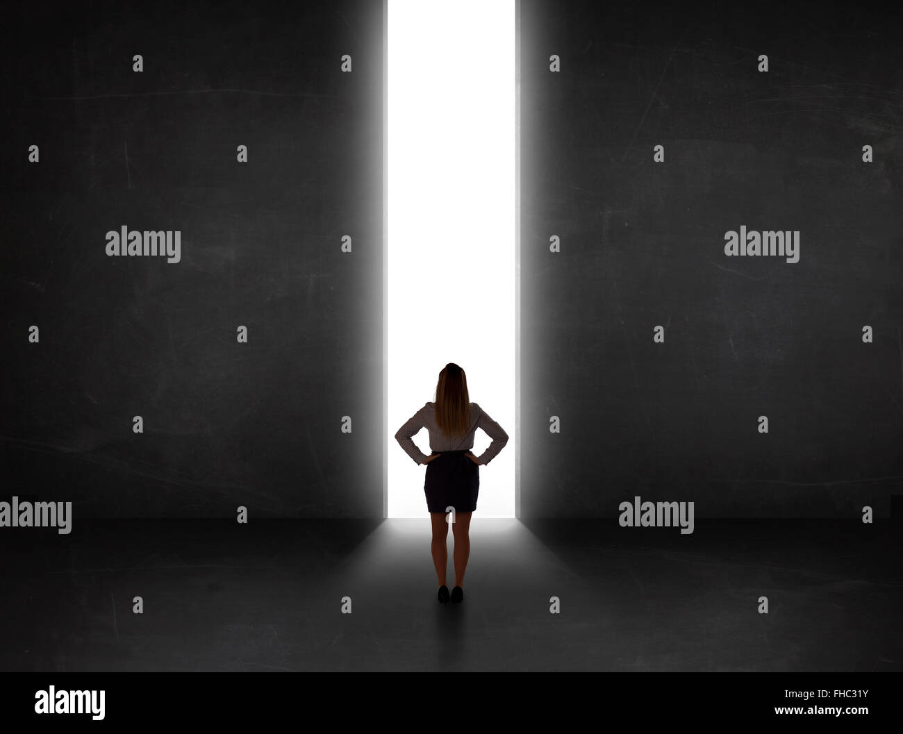 Business person looking at wall with light tunnel opening Stock Photo ...