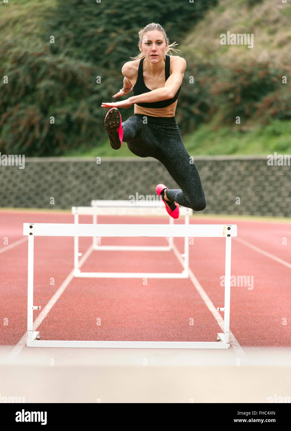 Athlete woman jumping in a running track Stock Photo - Alamy