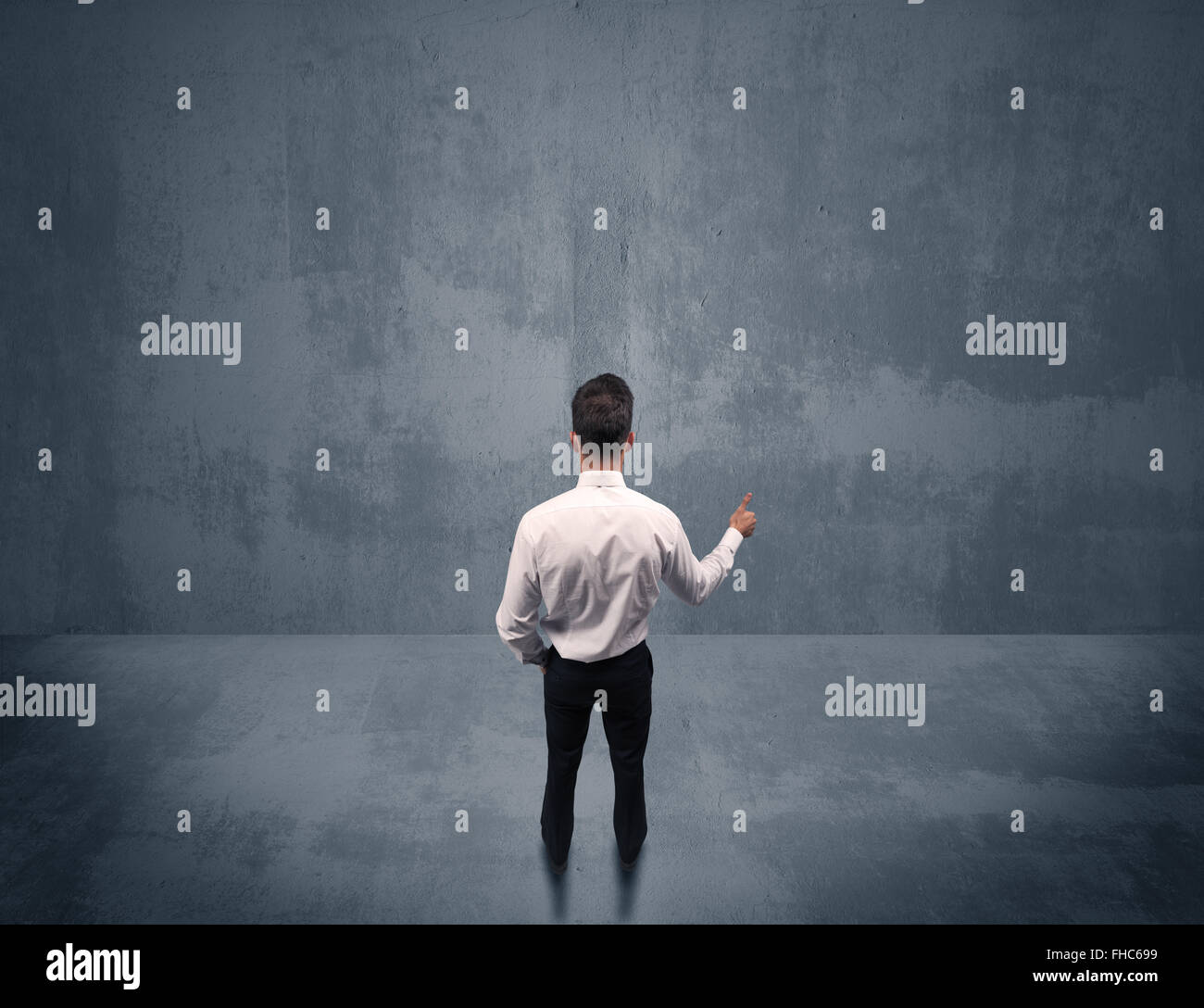 Businessman standing in front of urban wall Stock Photo - Alamy