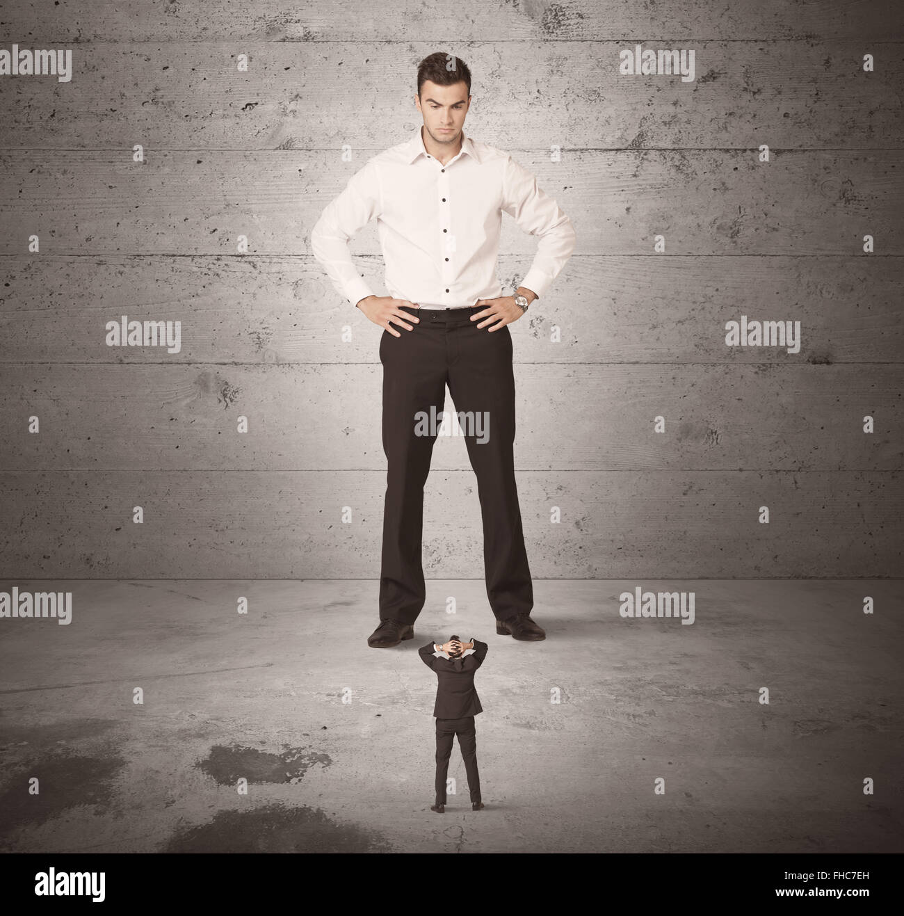 Huge business guy looking at small coworker Stock Photo - Alamy