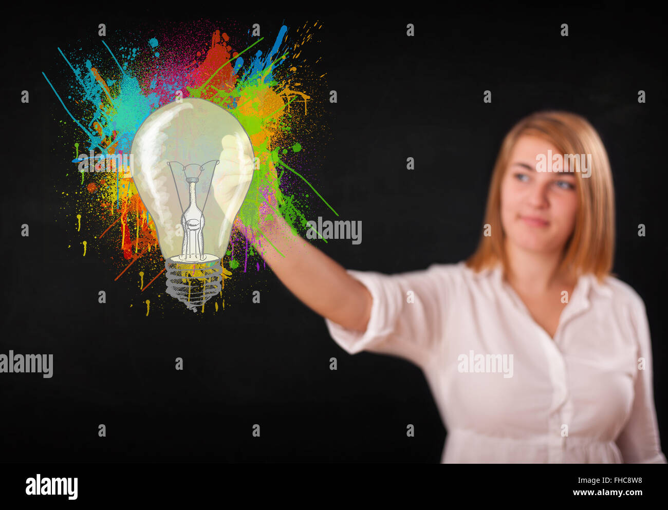 Young lady drawing a colorful light bulb with colorful splashes Stock ...