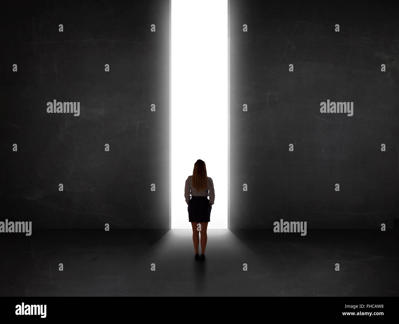 Business person looking at wall with light tunnel opening Stock Photo ...