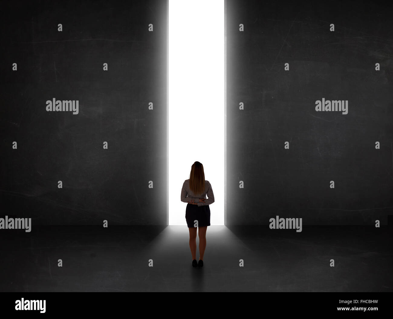 Business person looking at wall with light tunnel opening Stock Photo ...