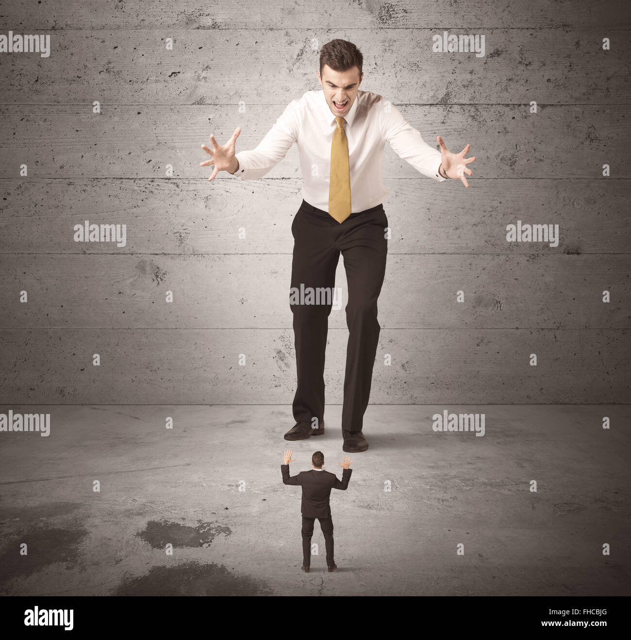 Huge business guy looking at small coworker Stock Photo - Alamy