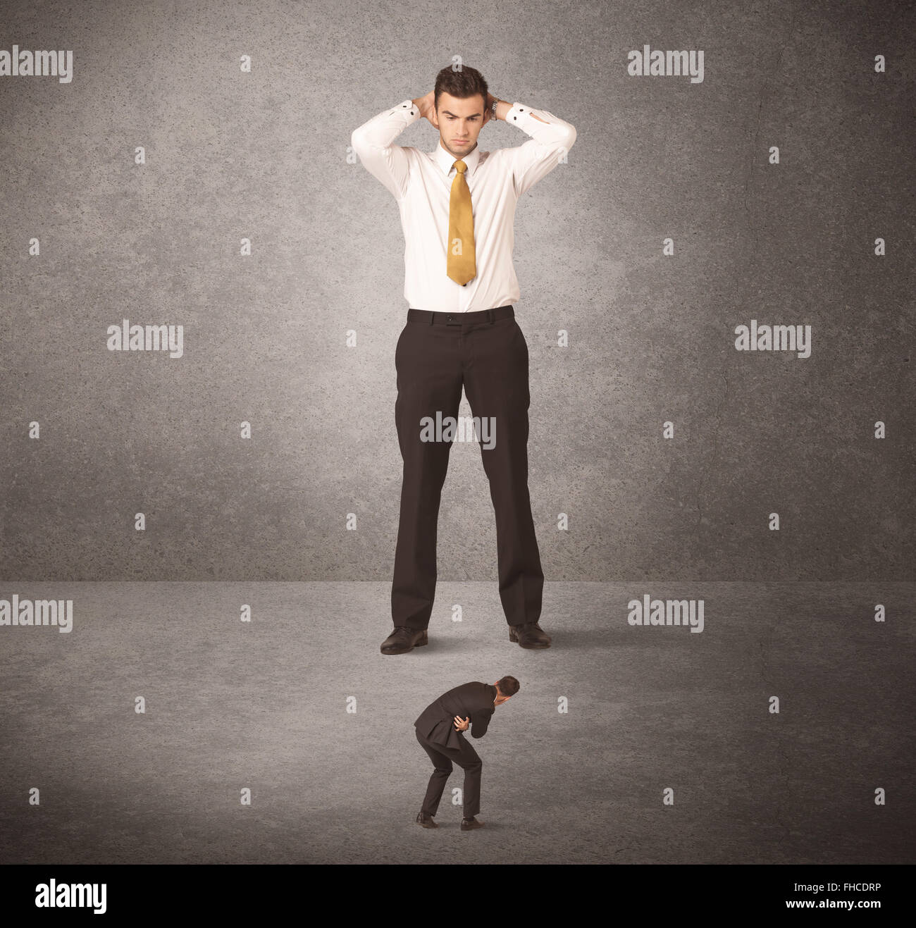 Big business man looking at small worker Stock Photo - Alamy