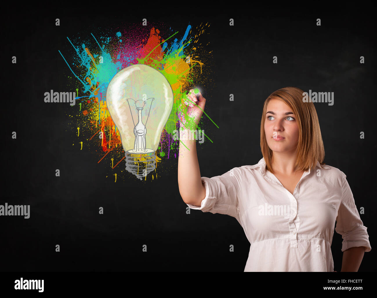 Young lady drawing a colorful light bulb with colorful splashes Stock ...