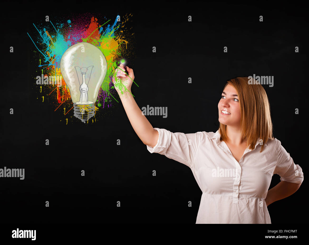 Young lady drawing a colorful light bulb with colorful splashes Stock ...