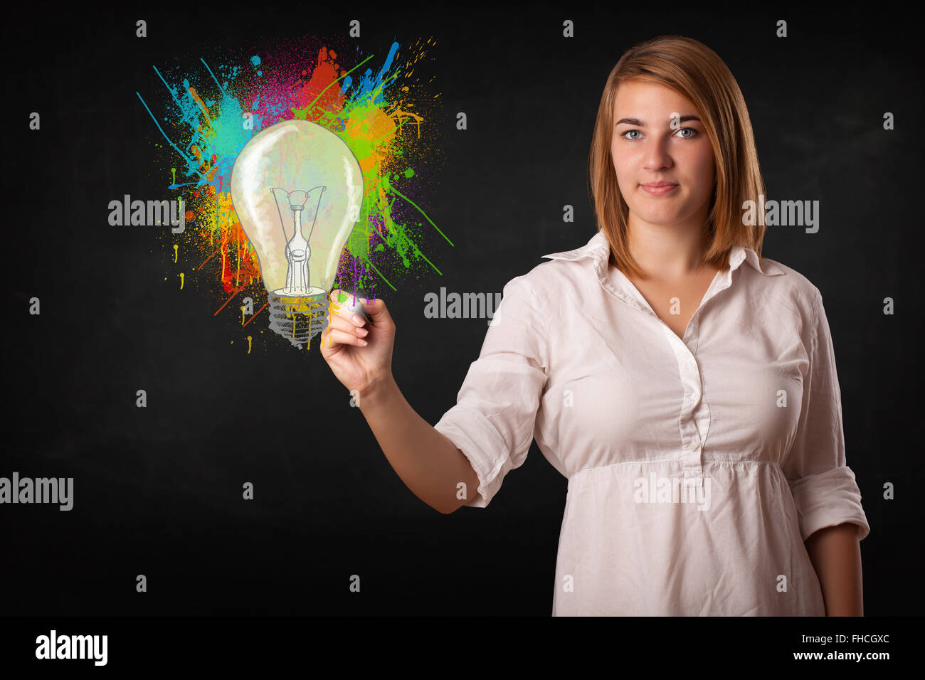 Young lady drawing a colorful light bulb with colorful splashes Stock ...