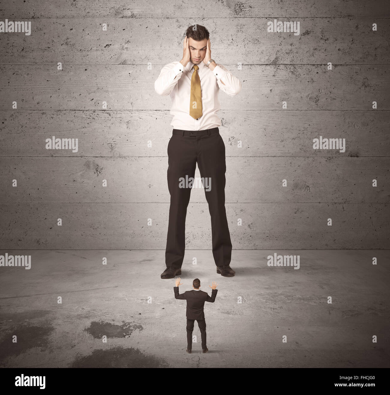 Huge business guy looking at small coworker Stock Photo - Alamy