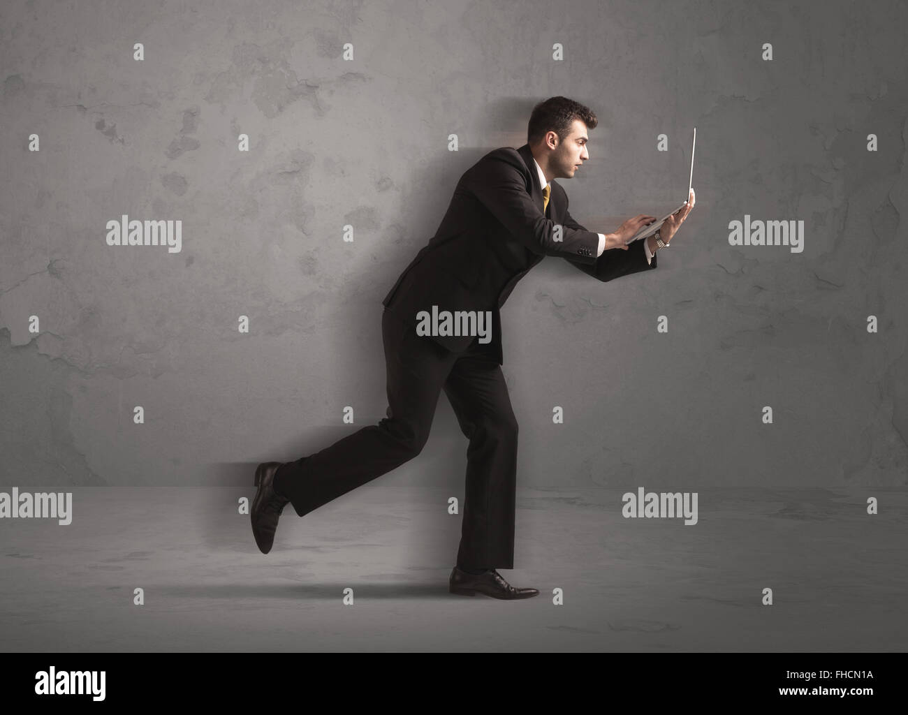 Running businessman with device in hand Stock Photo - Alamy