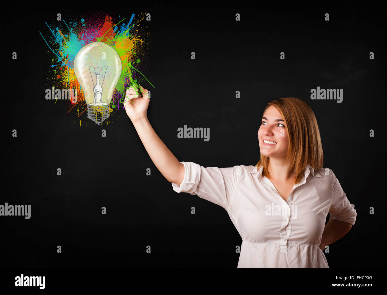 Young lady drawing a colorful light bulb with colorful splashes Stock ...