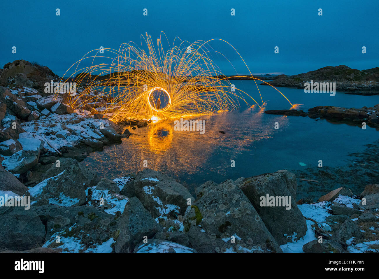 Norway, Lofoten, Ballstad, Spinning burning steel whool on the harbor ...