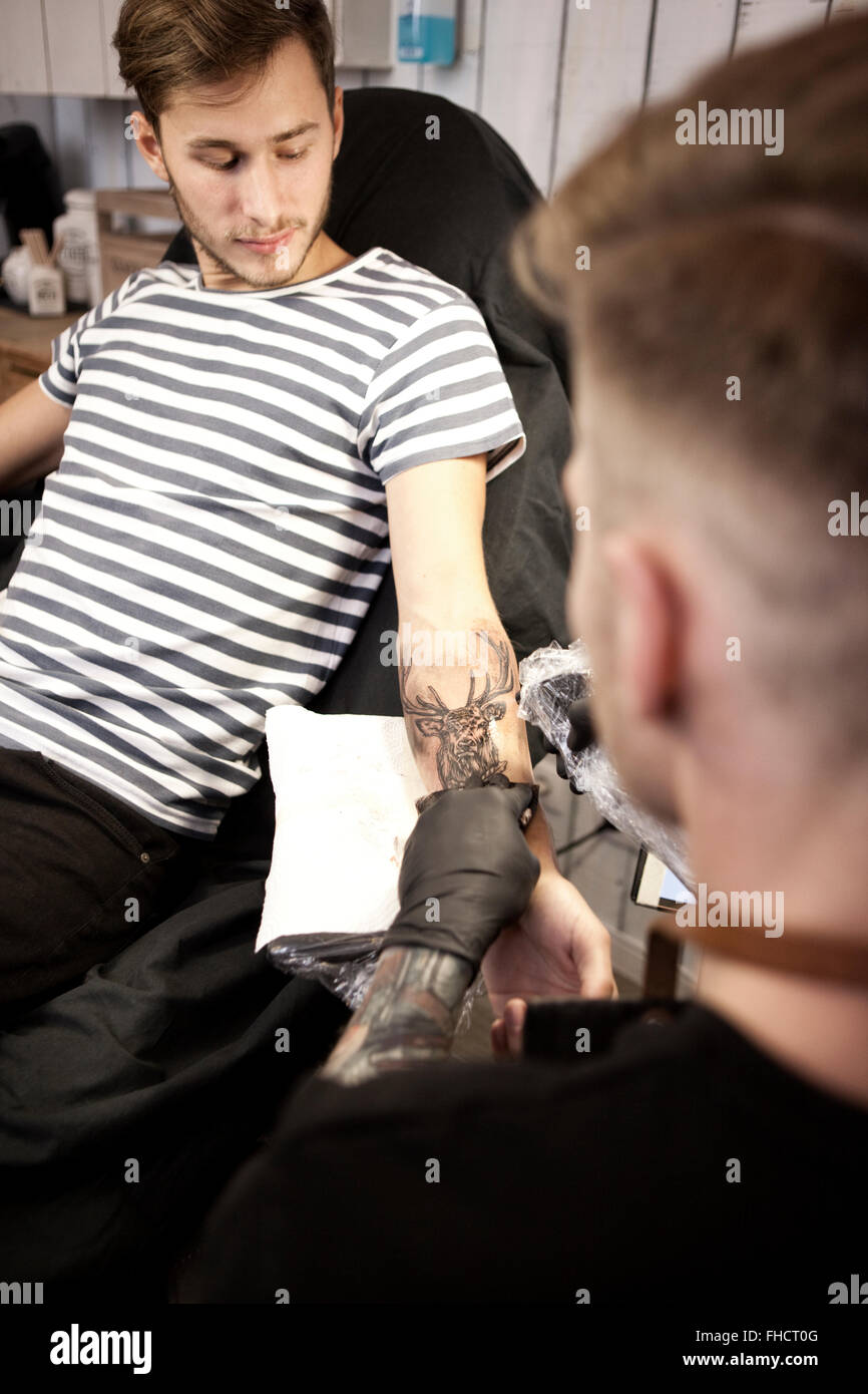 Tattooist at work in his tattoo studio Stock Photo - Alamy