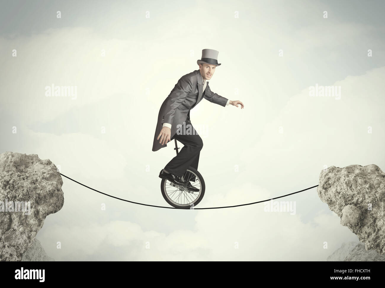 Brave business man riding an mono cycle between cliffs Stock Photo - Alamy