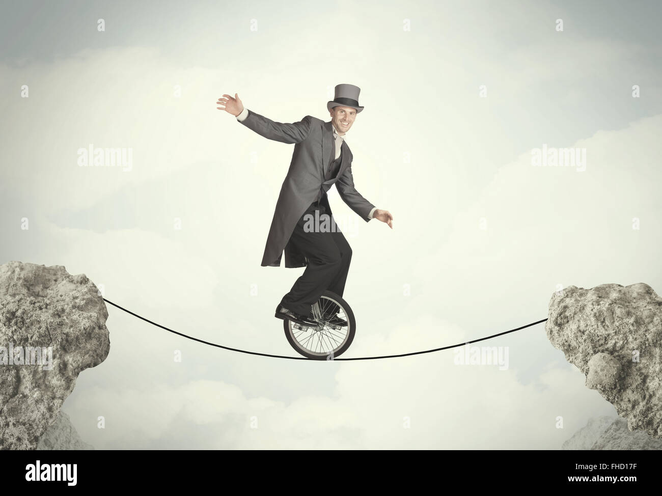 Brave business man riding an mono cycle between cliffs Stock Photo - Alamy