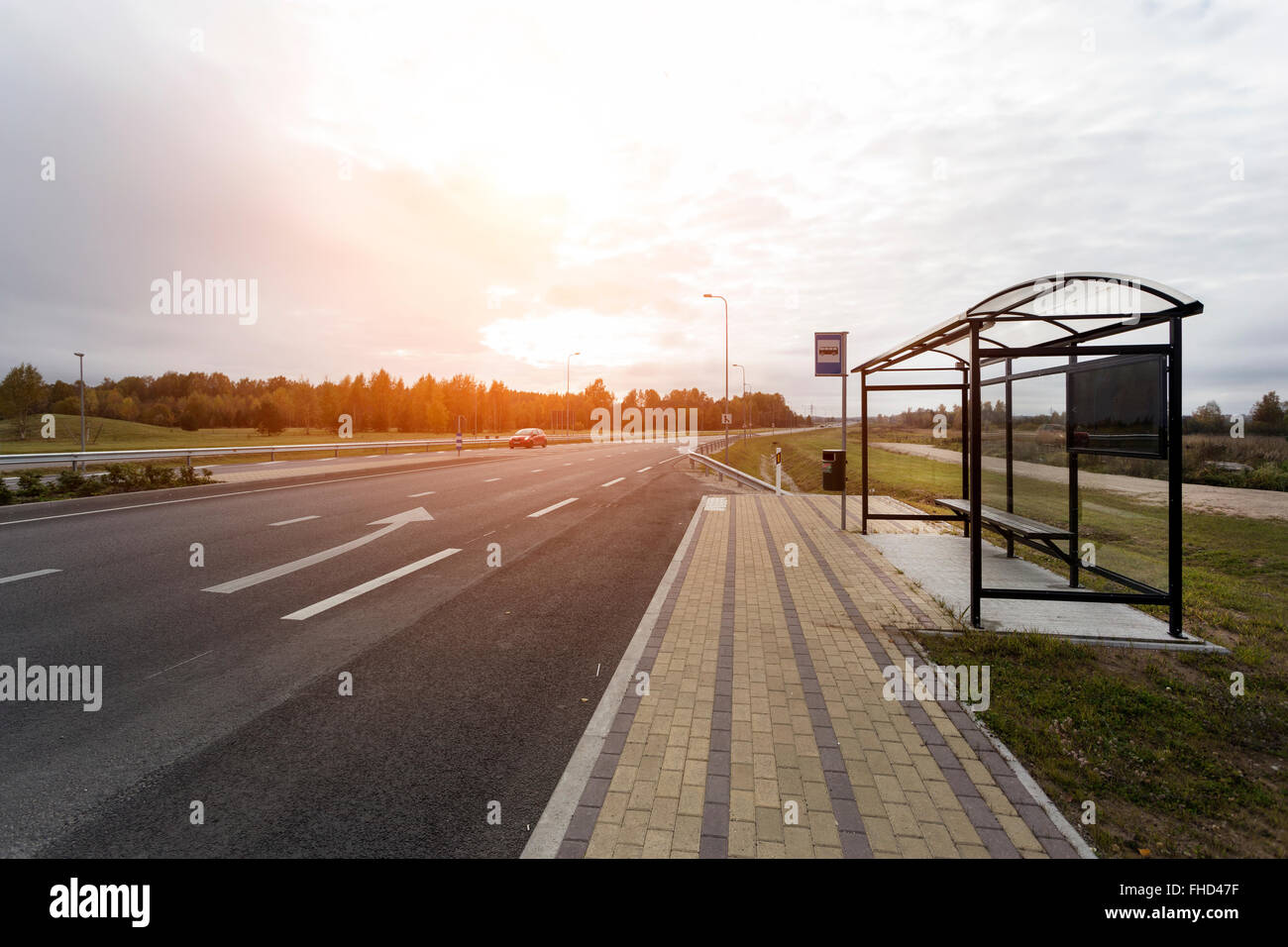Estonia, Tartu, Two lane street, divided road, bus stop at sunrise ...