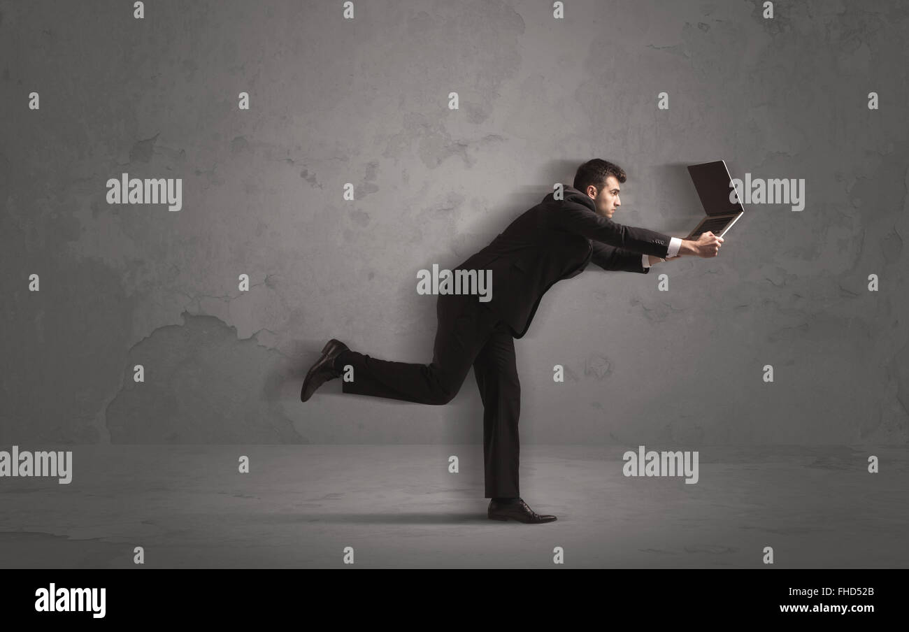 Running businessman with device in hand Stock Photo - Alamy