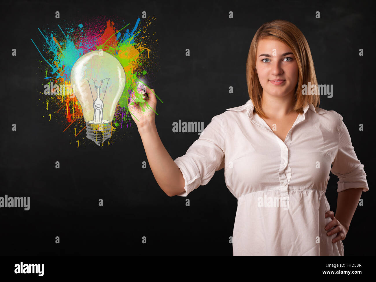 Young lady drawing a colorful light bulb with colorful splashes Stock ...