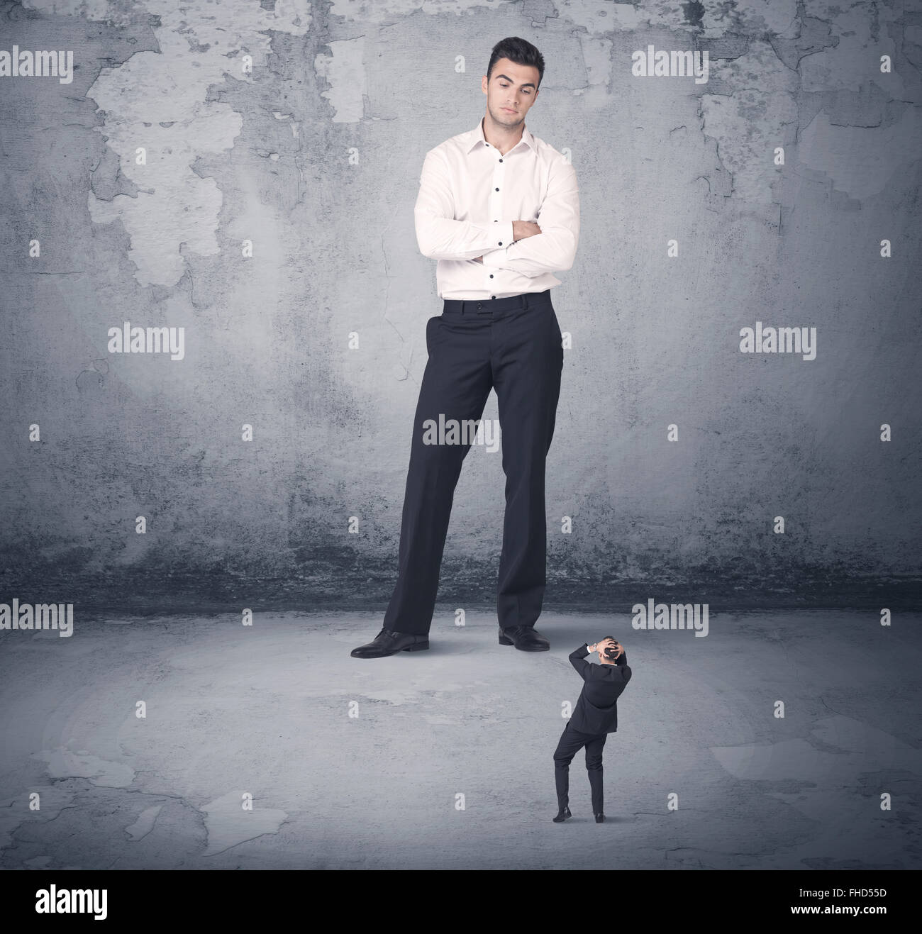 Big business bully looking at small coworker Stock Photo - Alamy