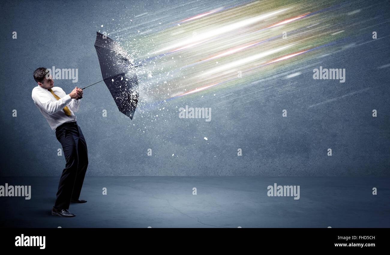 Business man defending light beams with umbrella concept Stock Photo ...
