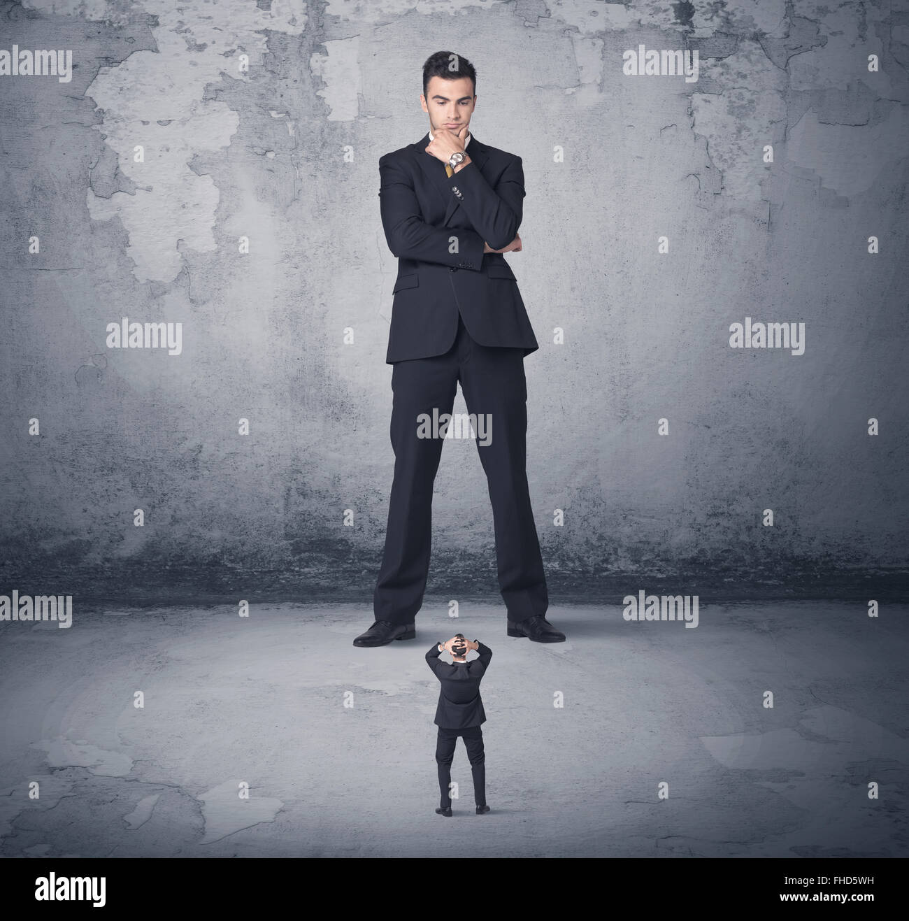 Big business bully looking at small coworker Stock Photo - Alamy