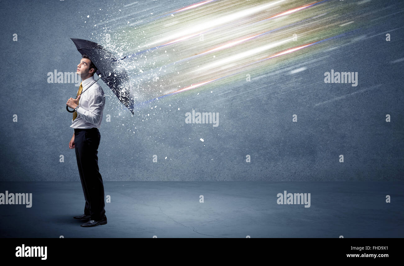 Business man defending light beams with umbrella concept Stock Photo ...