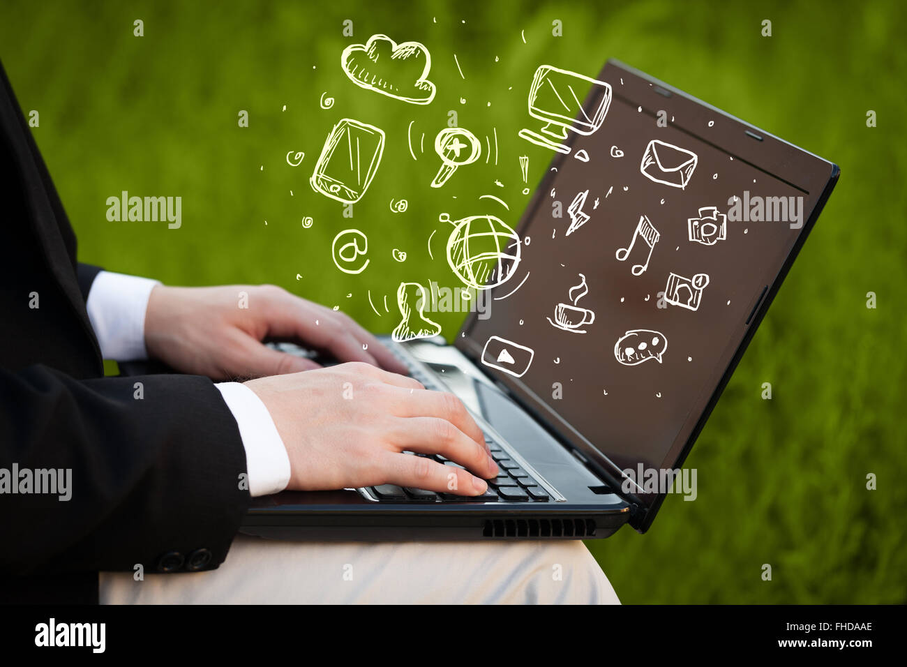 Hand writing on notebook computer with media icons Stock Photo - Alamy