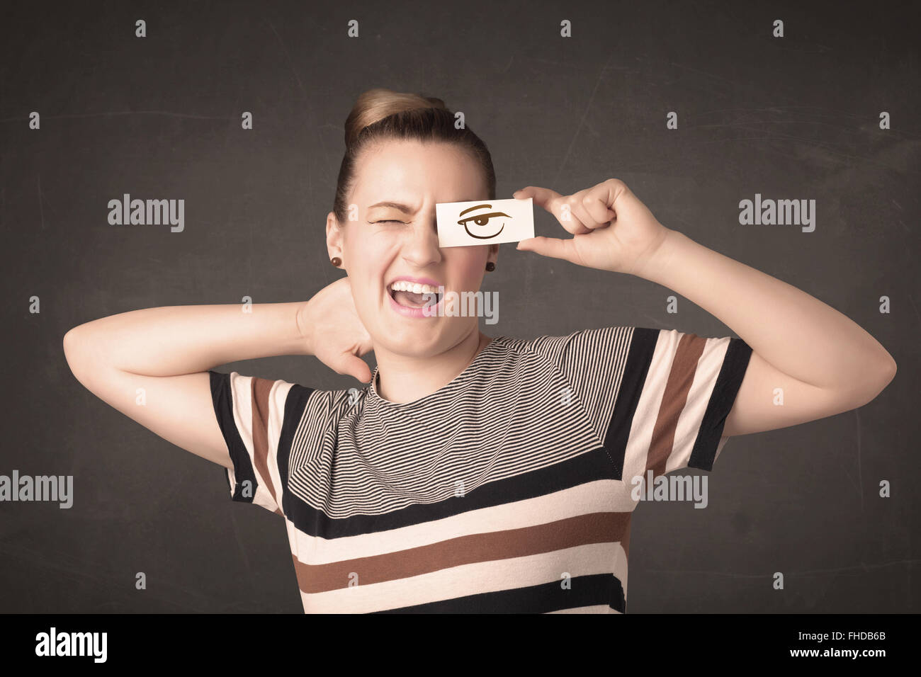 Young person holding paper with angry eye drawing Stock Photo - Alamy