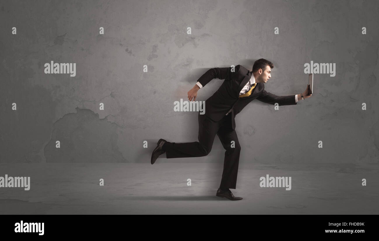 Running businessman with device in hand Stock Photo - Alamy
