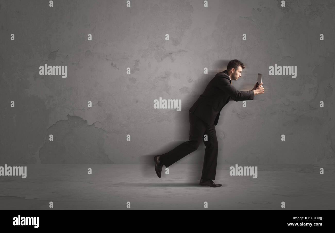 Running businessman with device in hand Stock Photo - Alamy