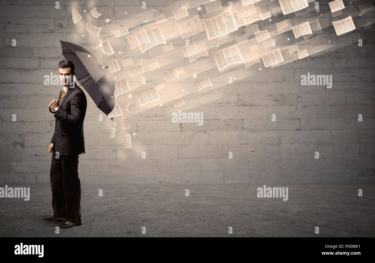 Business man protecting with umbrella against wind of papers Stock ...