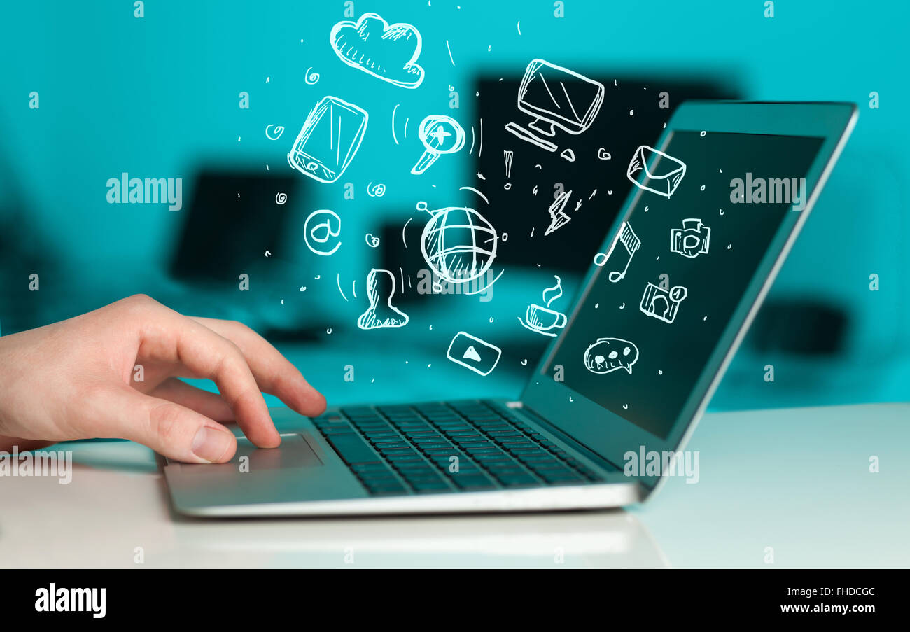 Hand writing on notebook computer with media icons Stock Photo - Alamy