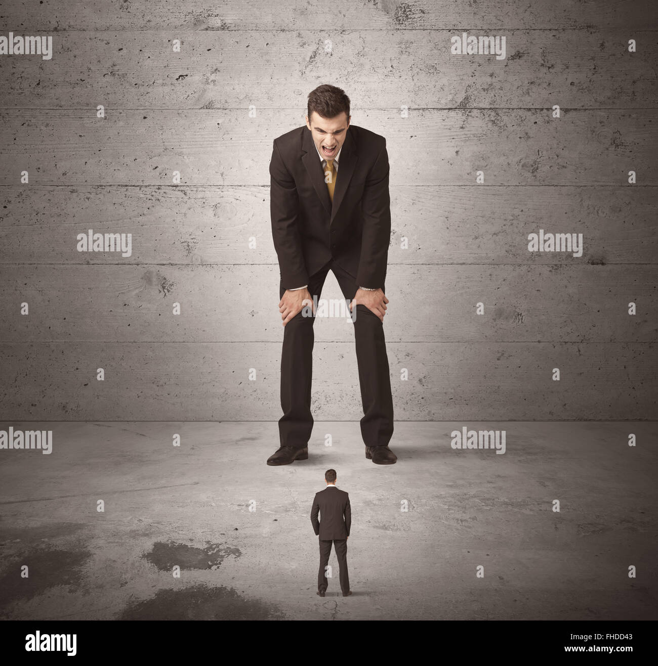 Huge business guy looking at small coworker Stock Photo - Alamy
