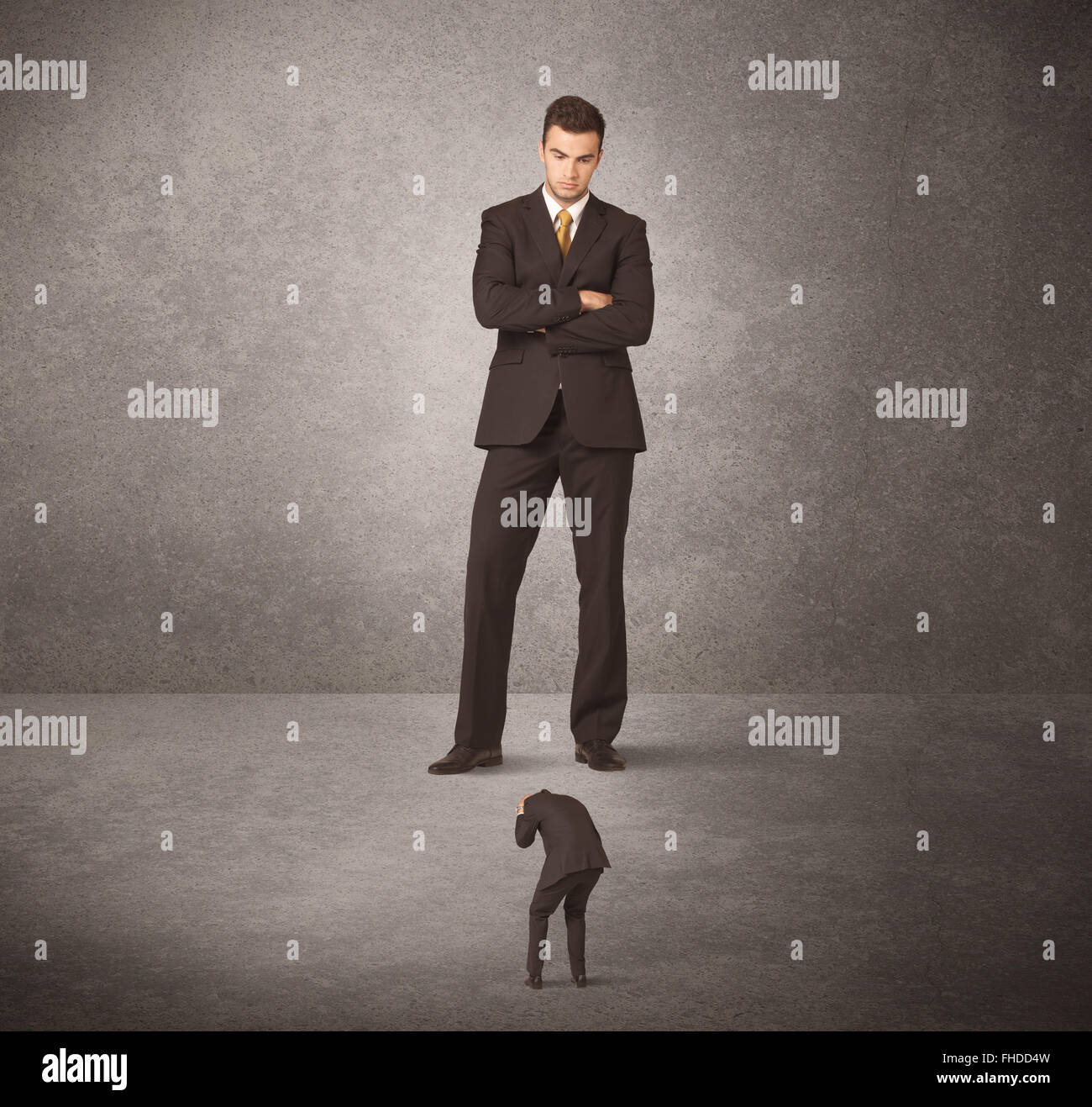 Big business man looking at small worker Stock Photo - Alamy