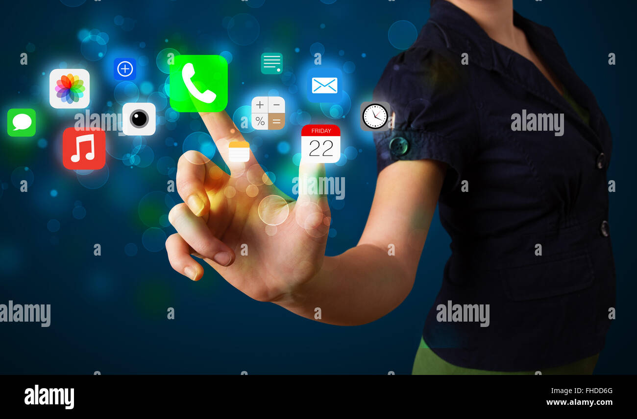 Young businesswoman pressing colorful mobile app icons with bokeh ...