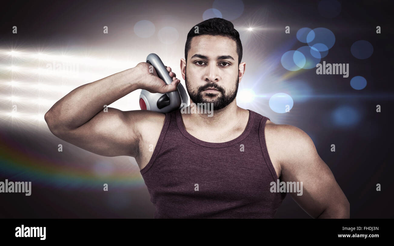 Composite image of muscular serious man holding a kettlebell Stock ...
